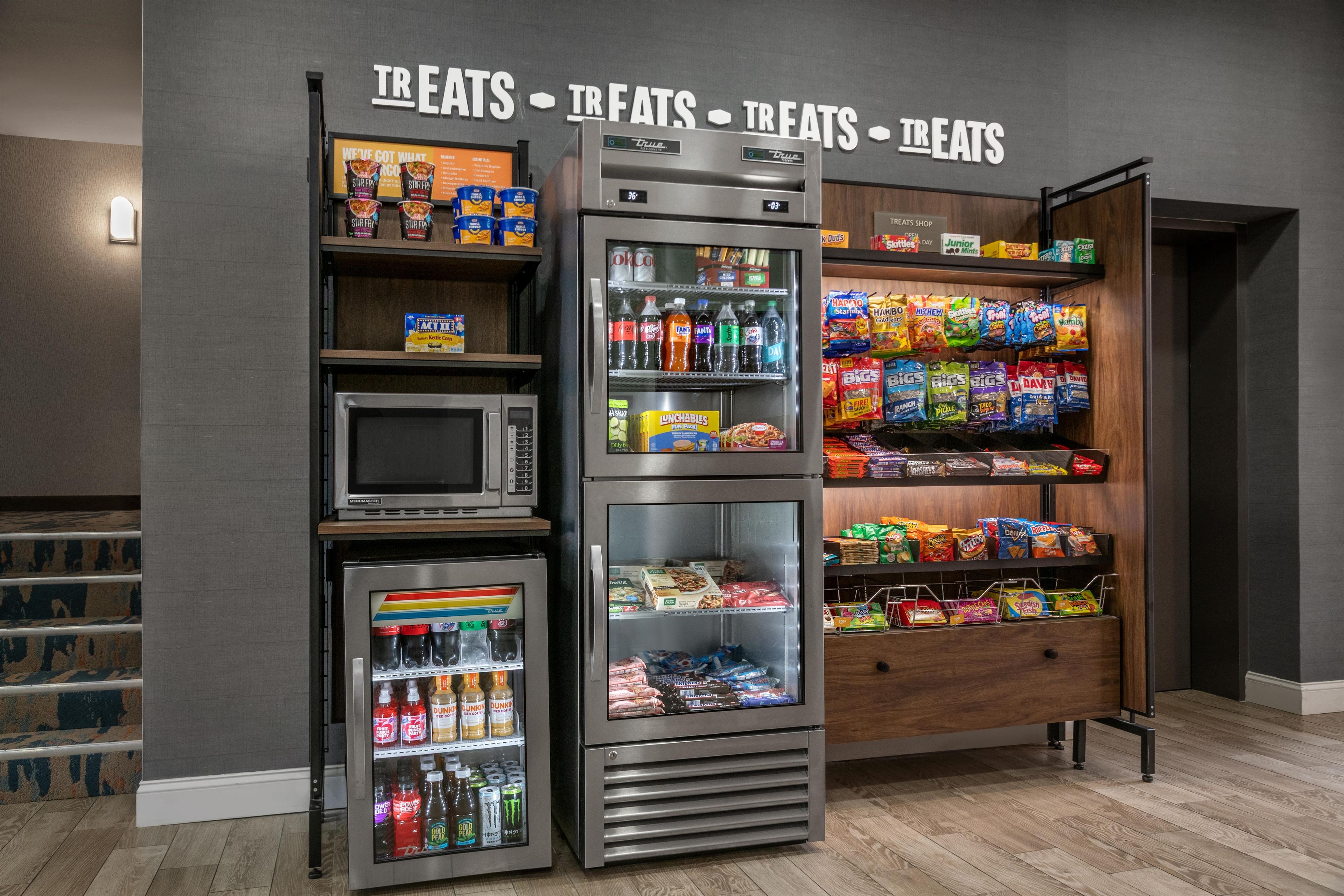 Área de máquinas de venda automática com lanches, bebidas e micro-ondas.