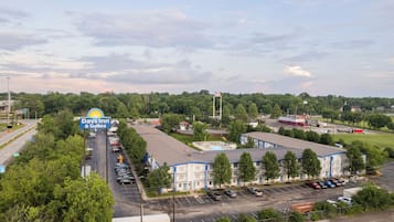 Um Days Inn & Suites com estacionamento, piscina e um edifício grande em esquema de cores azul e branco.