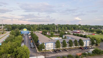 Um Days Inn & Suites com estacionamento, piscina e um edifício grande em esquema de cores azul e branco.