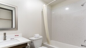 Casa de banho com lavatório, sanita e banheira brancos.