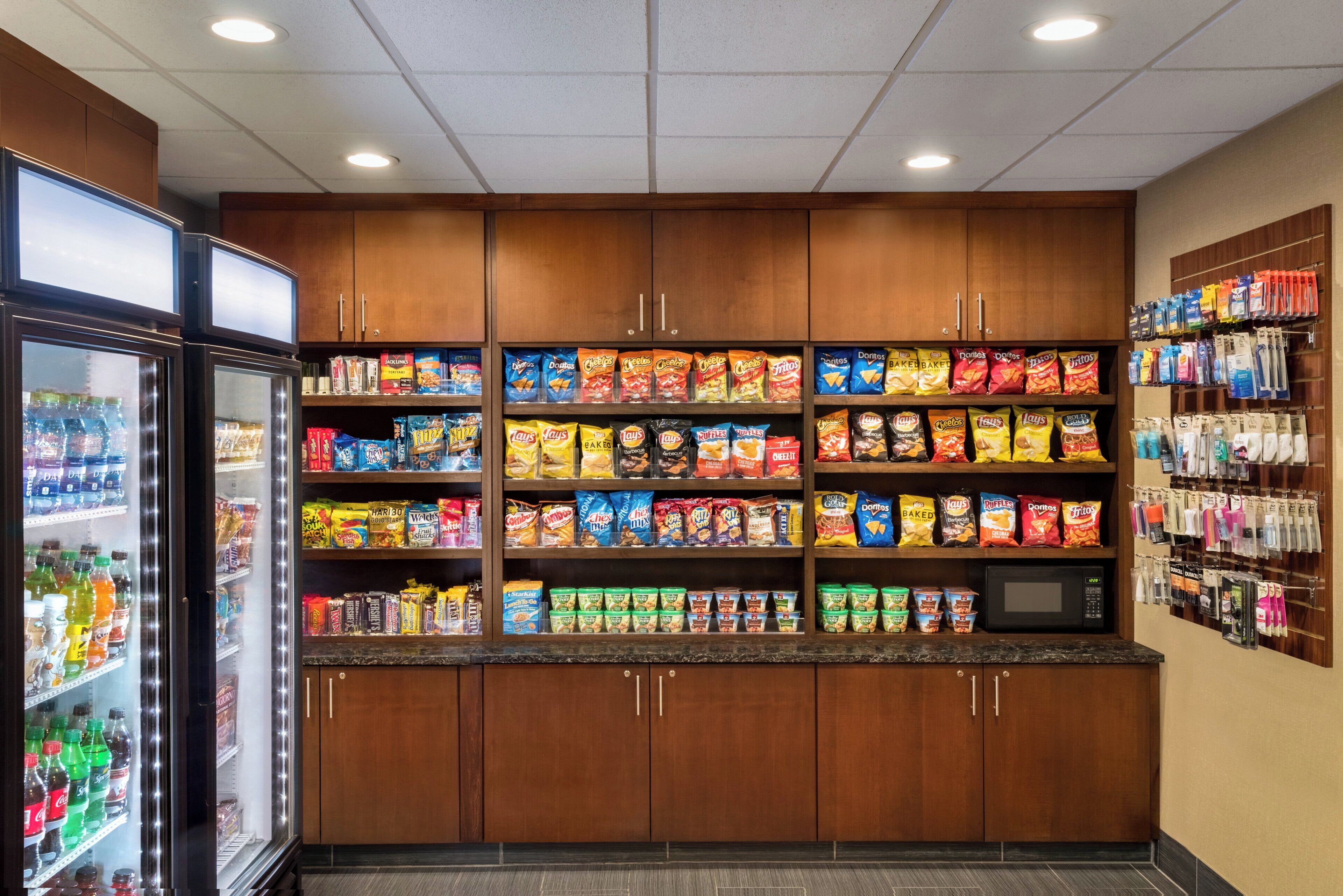 Uma área com petiscos e bebidas, incluindo diversas opções de lanches e refrigerantes embalados.