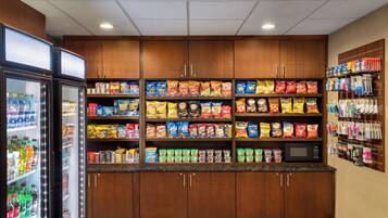 Uma área com petiscos e bebidas, incluindo diversas opções de lanches e refrigerantes embalados.
