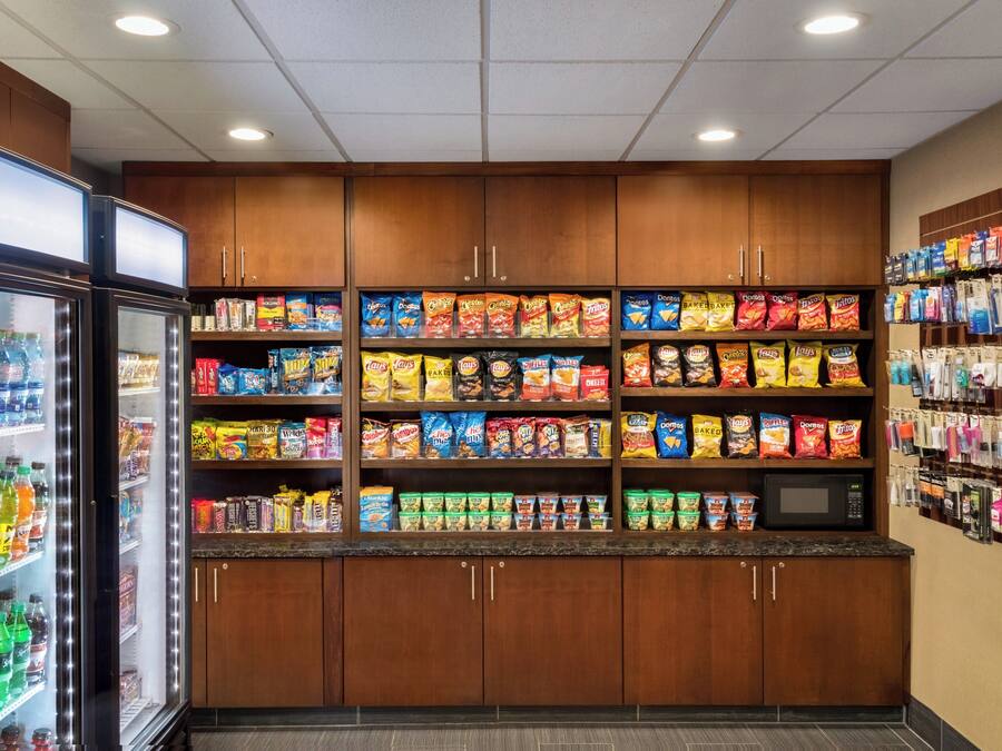 Uma área com petiscos e bebidas, incluindo diversas opções de lanches e refrigerantes embalados.