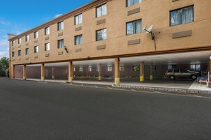 Um hotel com vários andares e área de estacionamento coberta.