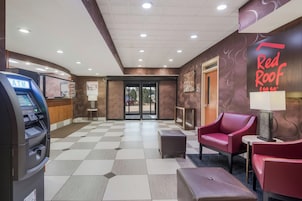 Lobby de um Red Roof Inn com caixa eletrônico, área de estar e balcão de check-in.