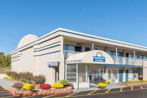 Edifício Days Inn & Suites com estacionamento, escritório e área de estar externa.
