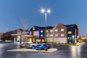 Um hotel Holiday Inn Express com um estacionamento, um carro azul e um caminhão.