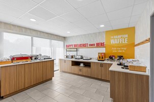 Cozinha moderna com balcão de café da manhã, estação de waffles e placa indicando que o café da manhã é servido aqui.