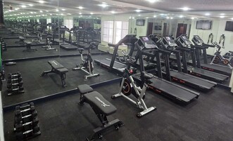 Uma academia com diversos equipamentos de exercício, incluindo esteiras, bicicletas ergométricas e aparelhos de musculação.