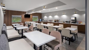 Um restaurante moderno com várias mesas e cabines, uma área de bar e uma televisão de tela plana.