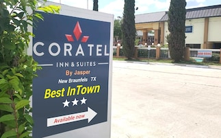 Placa de hotel do Coratel Inn & Suites em New Braunfels, TX, com um prêmio 'Melhor da Cidade' e uma seta apontando para a direita.