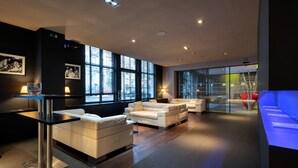 Uma sala de estar moderna com um sofá, uma mesa de centro e uma mesa lateral com abajur.