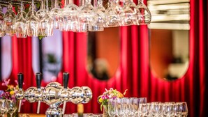 Uma área de bar com vários copos de vinho e uma garrafa de champanhe.