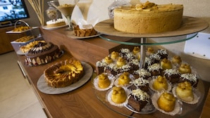 Buffet com diversos doces, incluindo bolos, brownies e pastelaria.