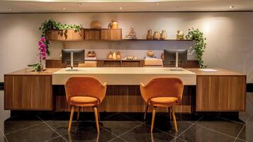 Cozinha moderna com dois banquetas, armários de madeira e objetos decorativos nas prateleiras.