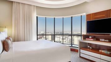 Quarto de hotel com cama grande, televisão e vista para a cidade.