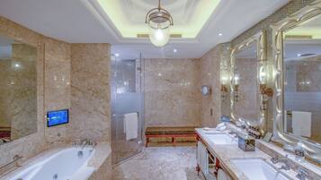 Um banheiro luxuoso com uma banheira grande, duas pias e um banco.