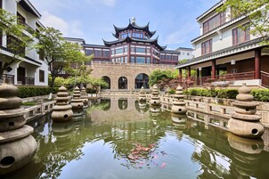 Um edifício tradicional com um pátio e um lago.