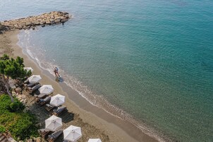 Na praia, espreguiçadeiras, guarda-sóis, toalhas de praia 