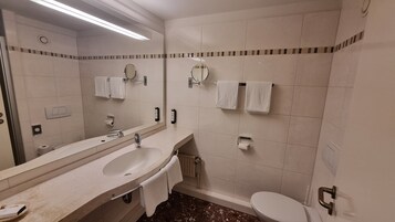 Casa de banho com duas pias, sanita e chuveiro.
