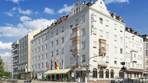 Um hotel com vários andares, fachada clássica, varandas e entrada no nível da rua.