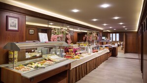 Disposição de buffet com diversos alimentos e um balcão extenso.