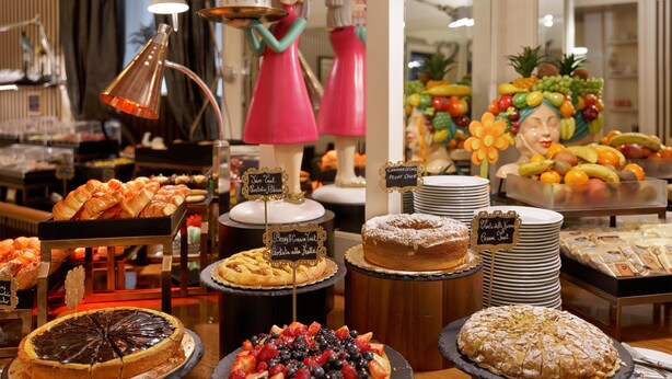 Vitrine de padaria com diversos bolos e doces.