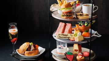 Bandeja escalonada com diversos alimentos e uma taça de champanhe.