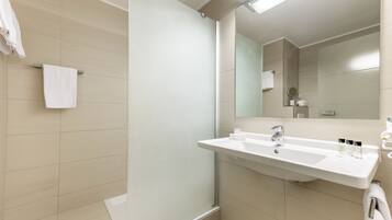 Casa de banho moderna com um espelho grande, duas pias e um porta-toalhas.