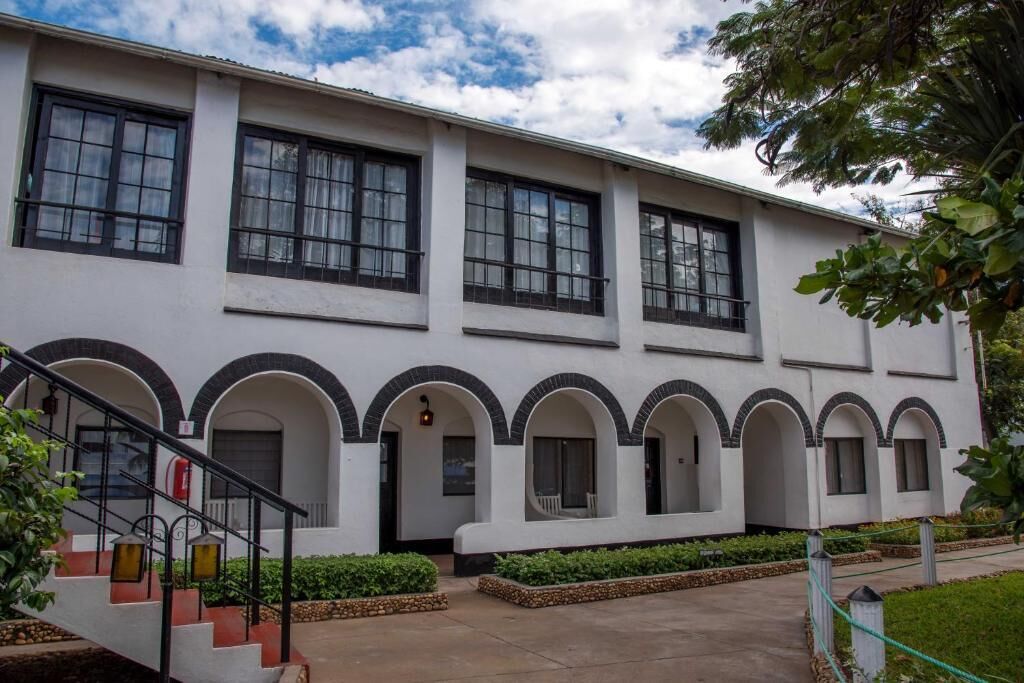 Um edifício com uma série de janelas em arco e uma escadaria central que leva a uma entrada.