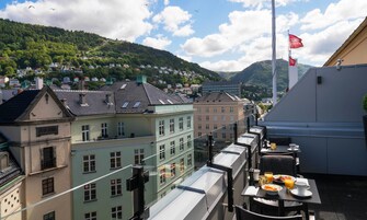 Hotel com terraço que oferece vista para uma cidade e montanhas.