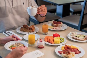 Uma mesa de café da manhã com diversos pratos, incluindo torradas, ovos e frutas.