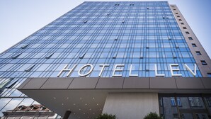 Um edifício moderno de hotel com um destaque para a placa "HOTEL LEV".