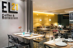 Interior moderno de cafeteria e restaurante, com design limpo e minimalista, destacando uma placa EL21 na parede.