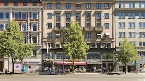 Um edifício com vários andares e um restaurante no andar térreo chamado "LA CAFE".