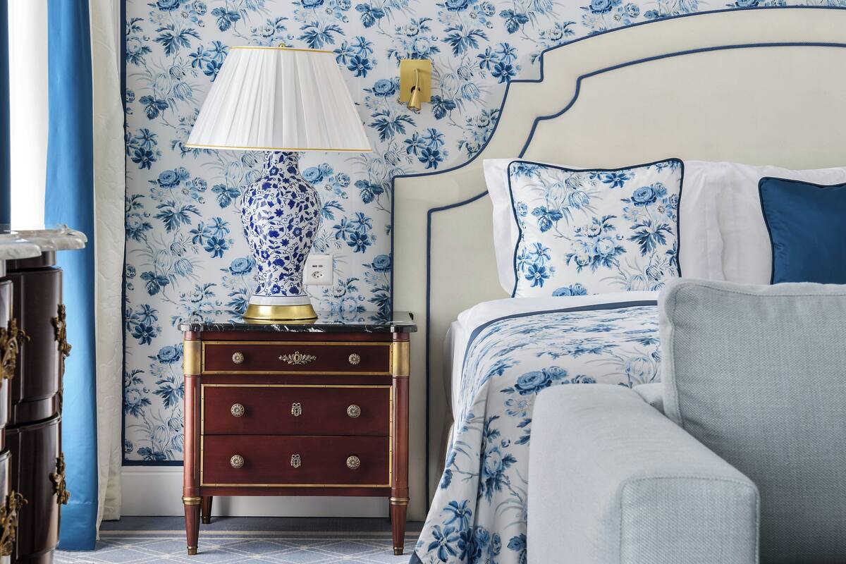 Quarto com cama, mesa de cabeceira, abajur e cômoda.