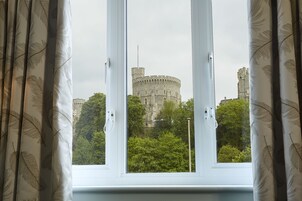 Vista de um castelo através de uma janela com cortinas.