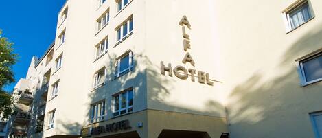 Um edifício de hotel com vários andares, com uma placa que diz 'LEA HOTEL'.