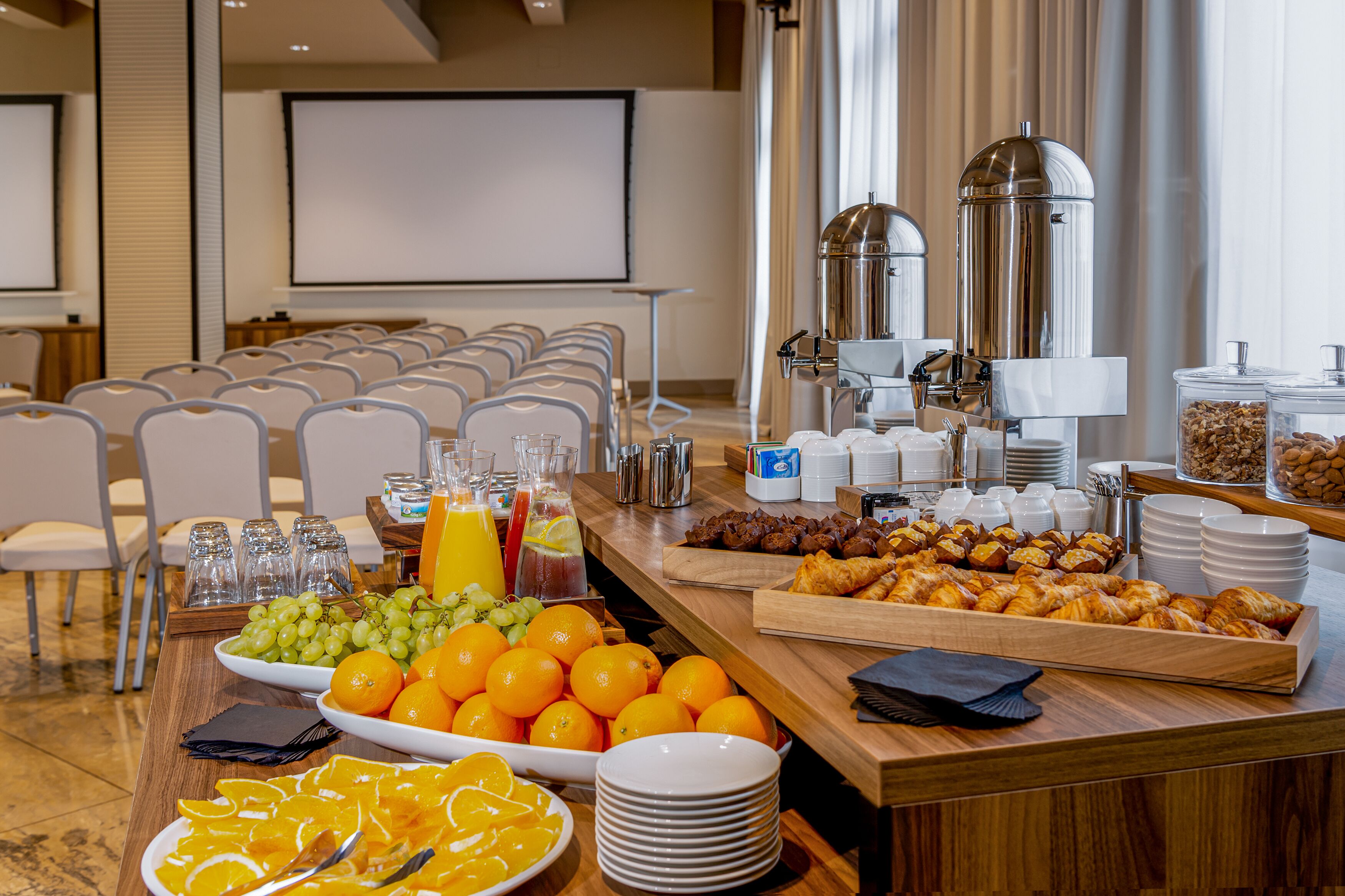 Buffet de café da manhã com frutas, doces e bebidas.