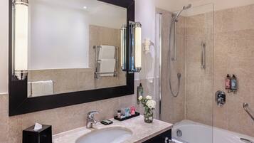Uma casa de banho moderna com um espelho grande, uma pia, uma banheira e um chuveiro.