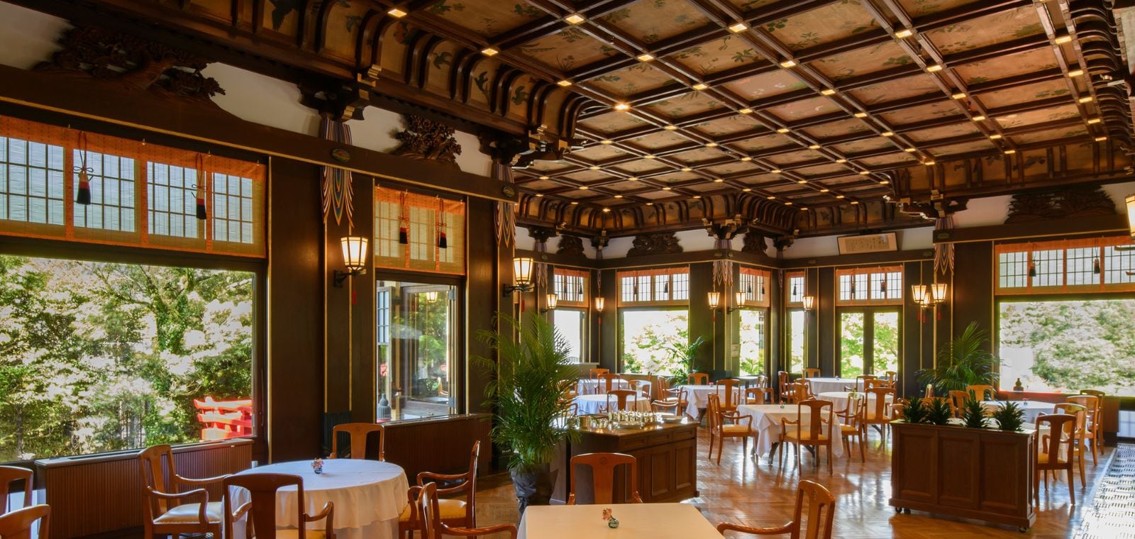 Um restaurante francês espaçoso que oferece café da manhã completo e cozinha francesa clássica, com interiores em madeira e janelas amplas.