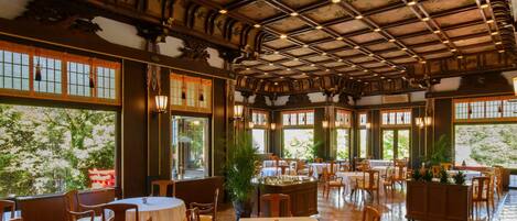 Um restaurante francês espaçoso que oferece café da manhã completo e cozinha francesa clássica, com interiores em madeira e janelas amplas.