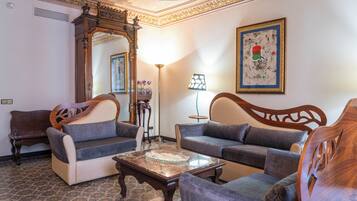 Quarto com dois sofás, uma mesa de centro de madeira, um abajur e um espelho grande.