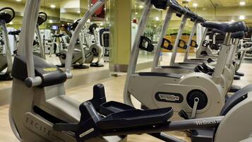 Ginásio com várias máquinas de cardio, incluindo esteiras e aparelhos elípticos.