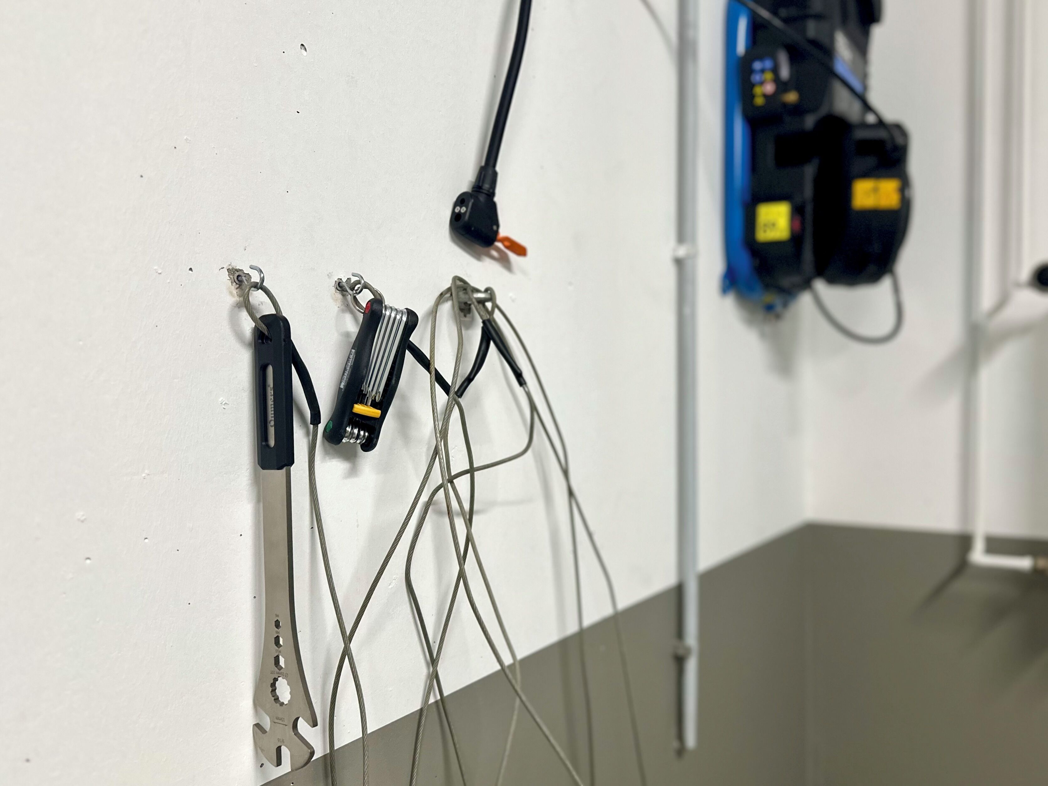 Quadro elétrico fixado na parede, com diversas ferramentas e cabos.