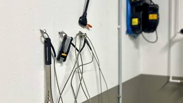 Quadro elétrico fixado na parede, com diversas ferramentas e cabos.