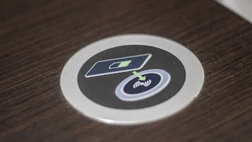 Um autocolante circular com um ícone de bateria e um símbolo de Wi-Fi numa superfície de madeira.