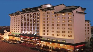 Um hotel com vários andares, teto plano e um amplo restaurante no térreo.