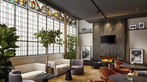 Uma sala de estar moderna com sofá, poltronas e mesas, janelas amplas com vitrais e uma TV de tela plana na parede.