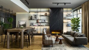 Uma sala de estar moderna com uma mesa de jantar de madeira, um sofá e uma lareira.
